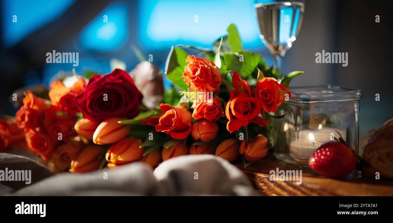 Romantic still life with red roses and tulips, champagne and ...