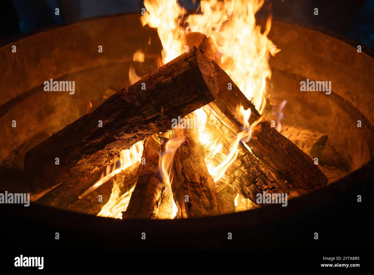 Blazing wood fire burning in a fire pit. Close-up of a warming campfire ...