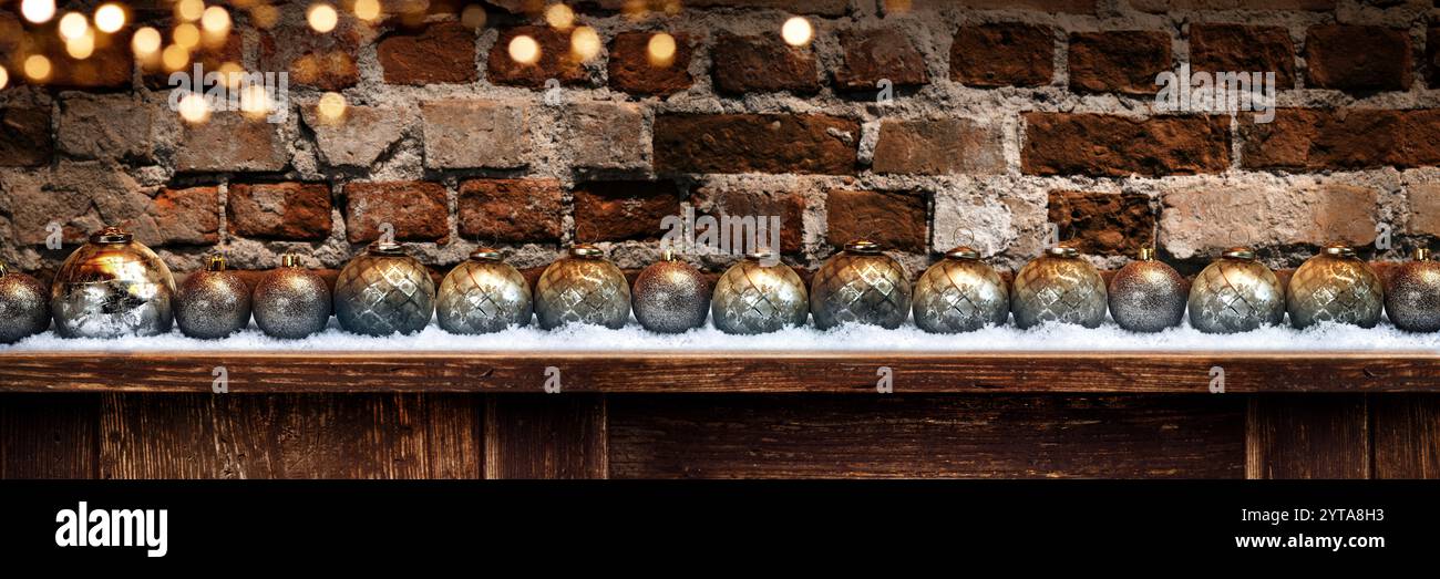 Row silver christmas balls outside in snow in front of old brick wall ...