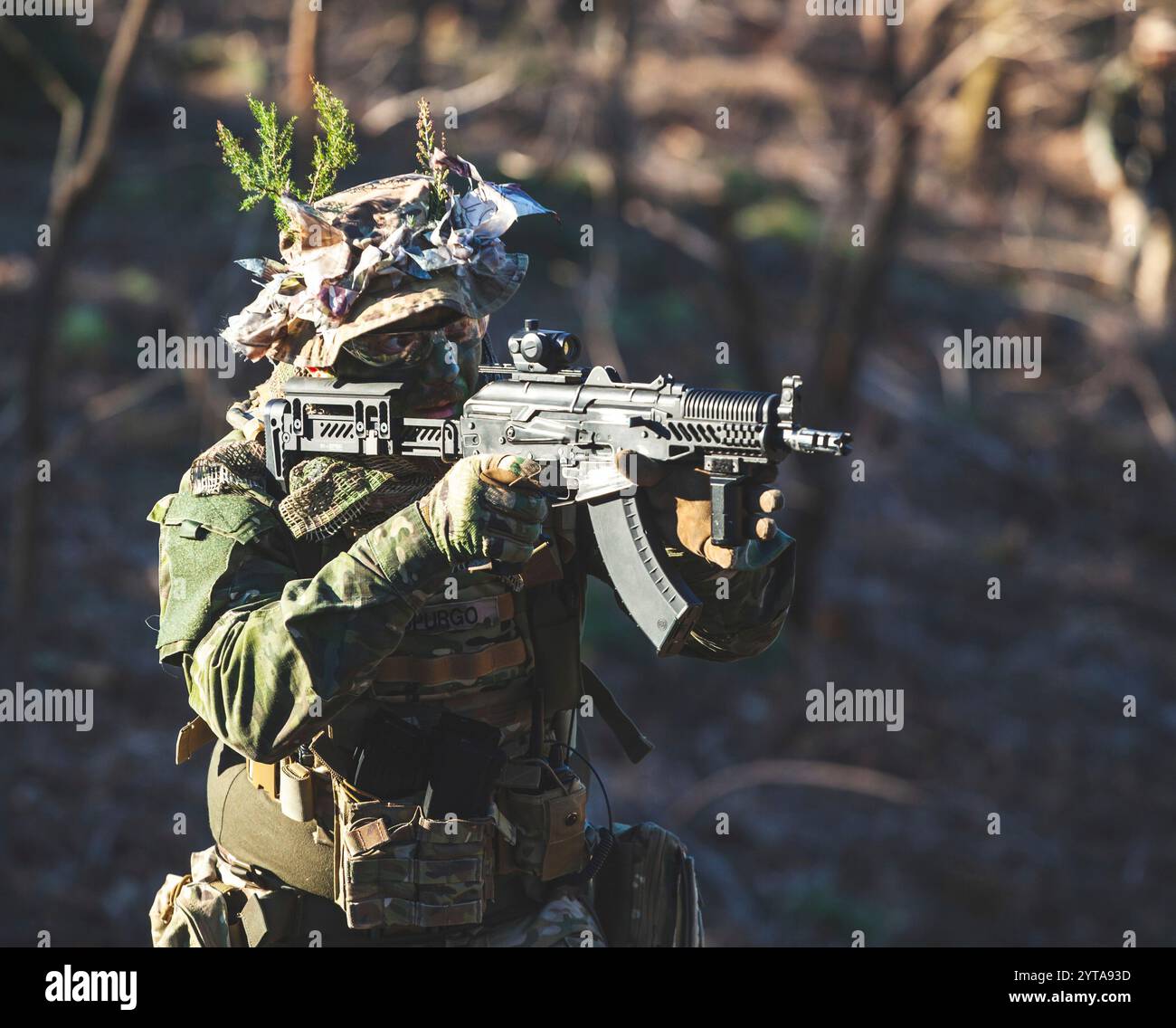 Airsoft military game player in camouflage uniform with armed assault ...