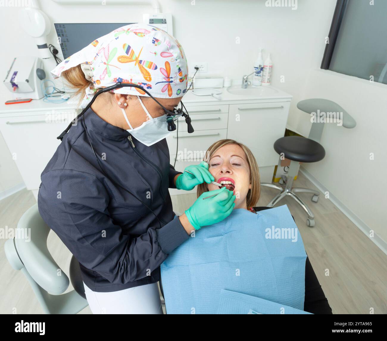 Young Blonde Female patient with open mouth examining dental inspection ...