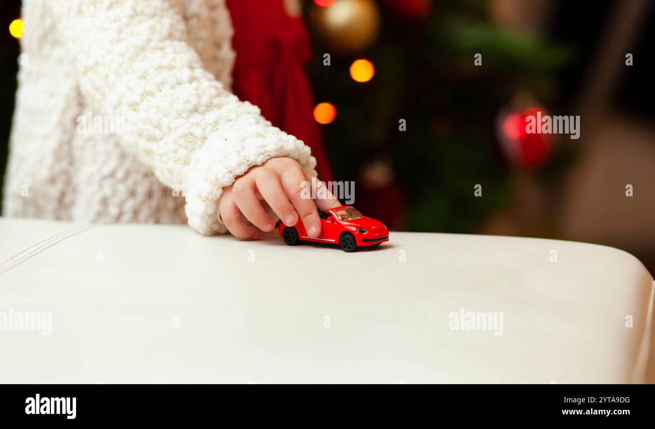 Beautiful little child plays with little red toy car Stock Photo - Alamy