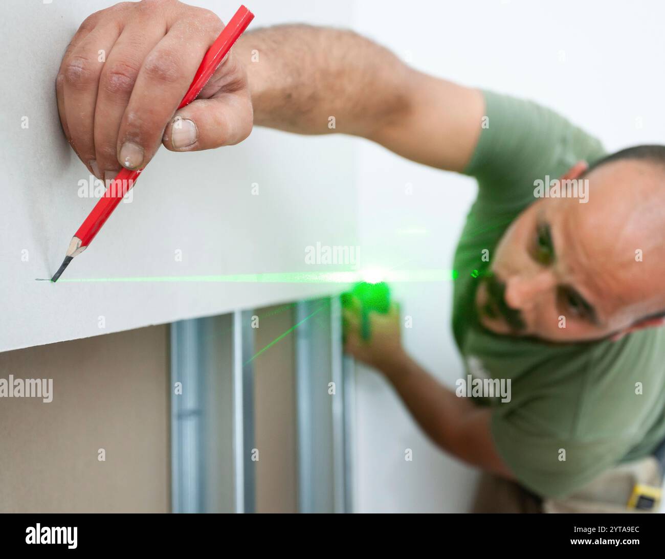 Worker building plasterboard wall Working with cutting tools, fixing ...