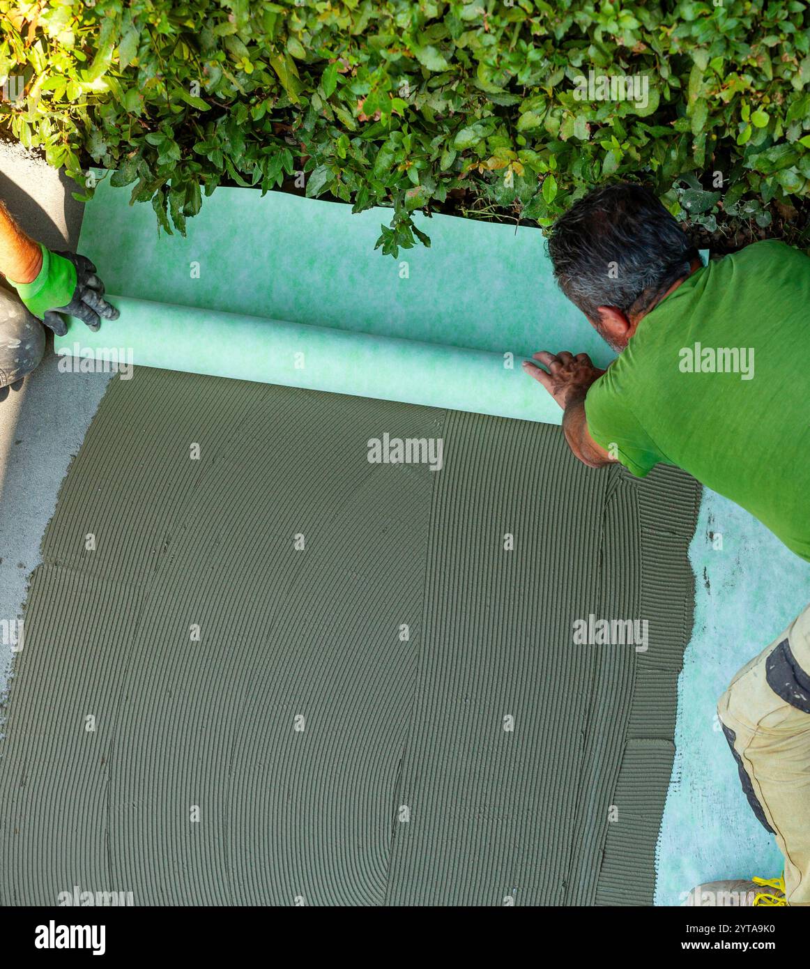 Laying a sound-absorbing mat on the screed Stock Photo - Alamy