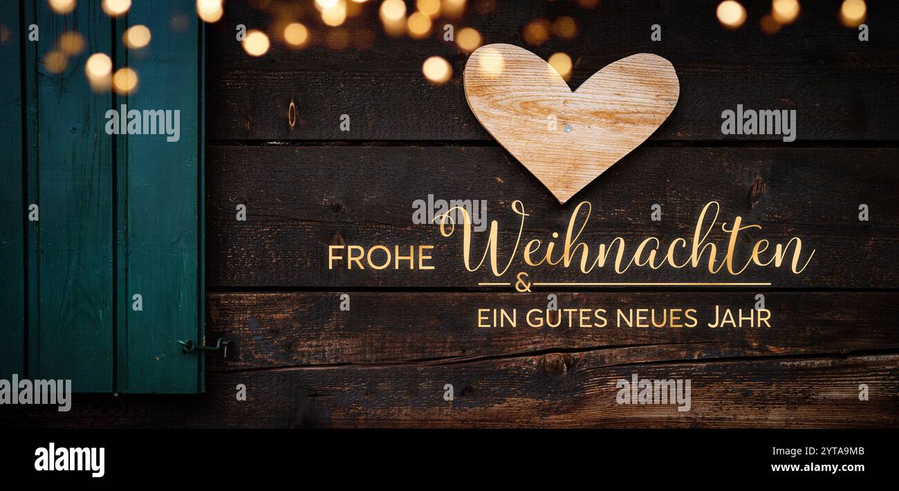 Christmas greetings in German language on dark wooden wall with green shutters and golden bokeh ...
