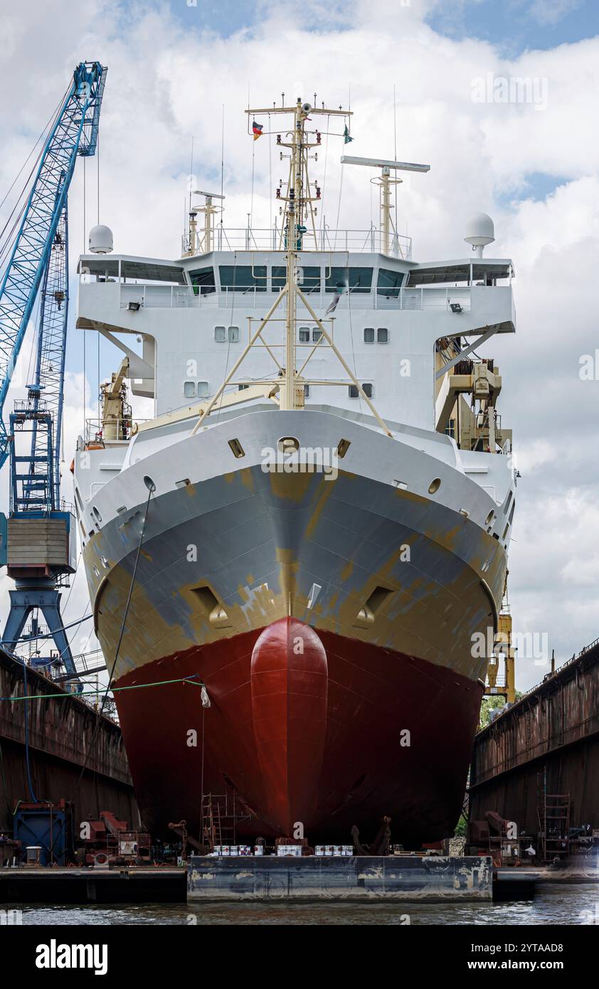 A cargo ship is in dry dock at a shipyard for repair work Stock Photo ...