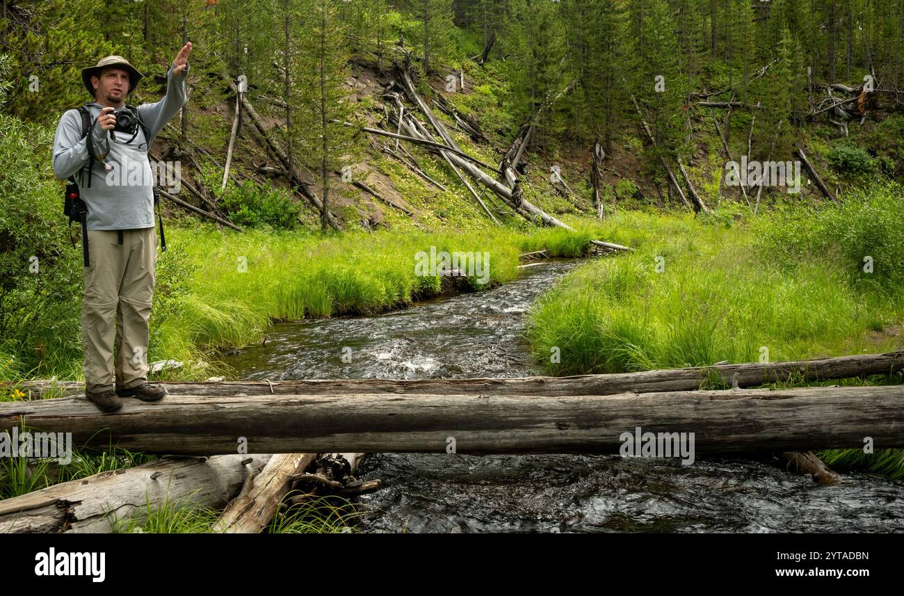 Photographer Pauses To Point Out Something While Crossing Tree Truck ...