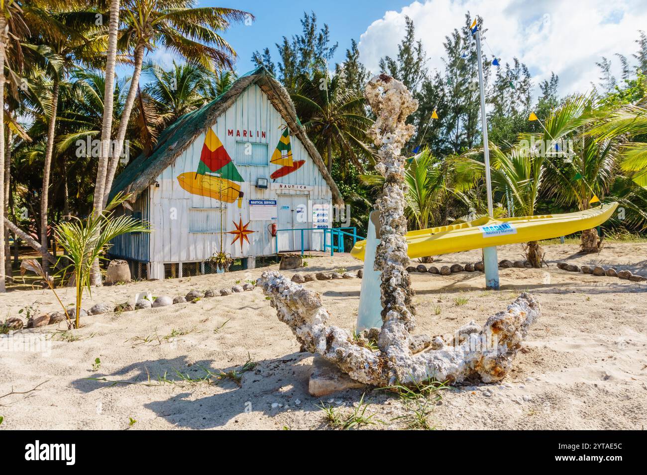 A small white building with a yellow and green roof. A yellow and blue ...