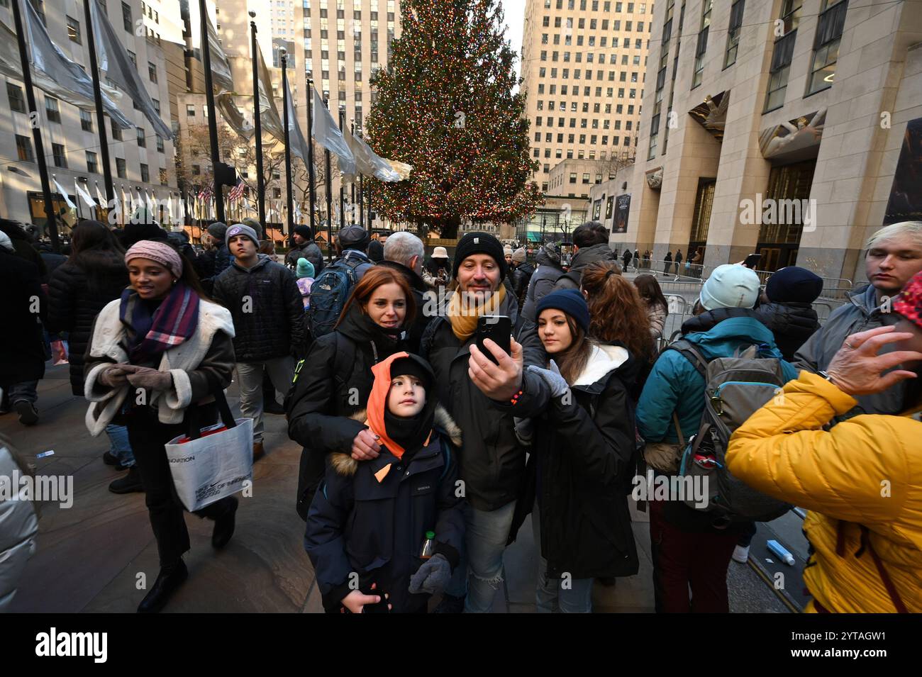 A family takes a picture of themselves with the Rockefeller Center ...