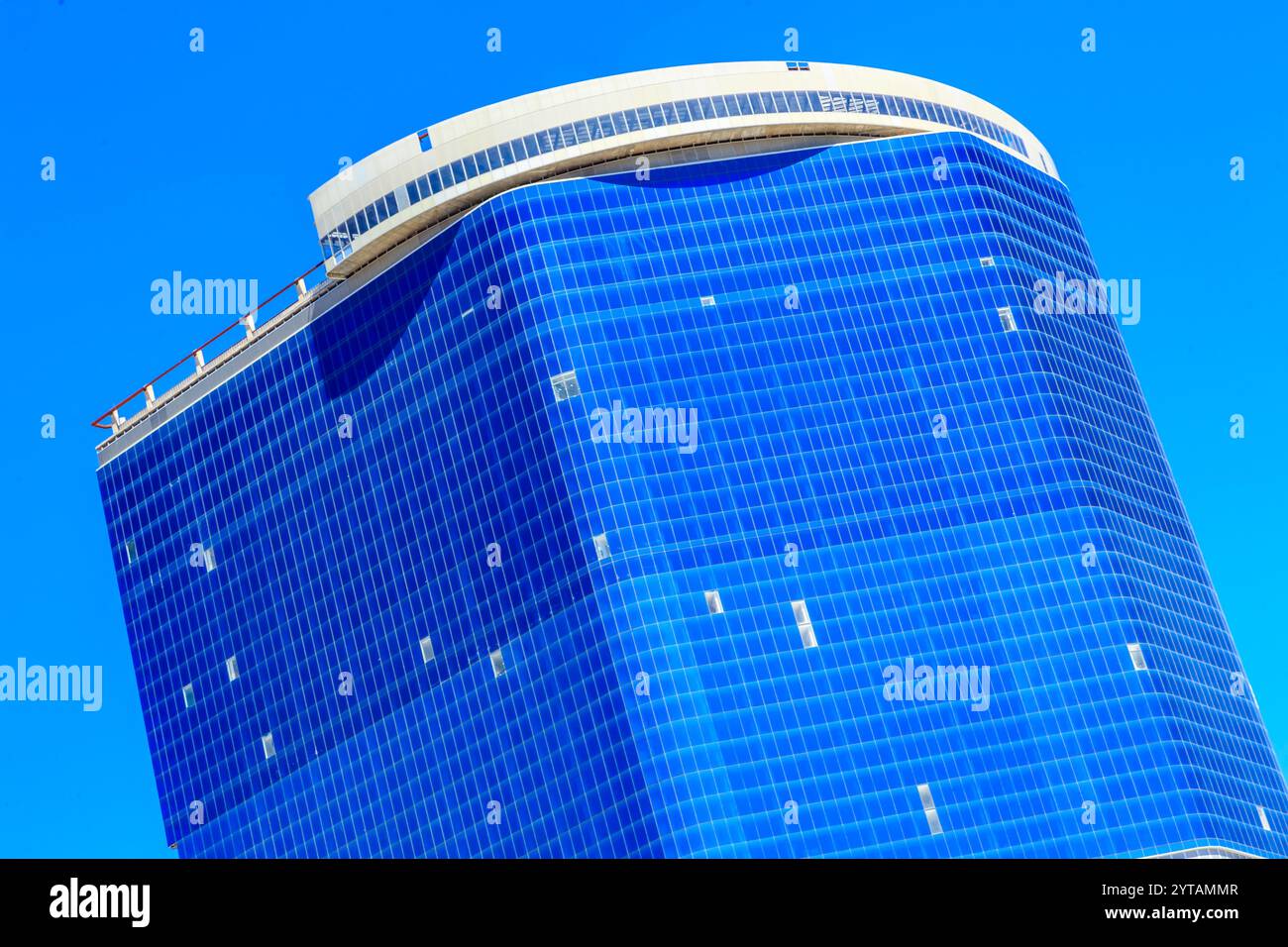 A large, modern building with a blue roof and many windows. The ...
