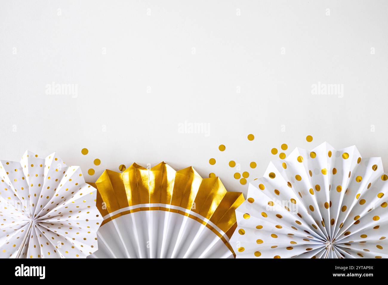 Tissue gold paper fans and honeycombs on the white background. Holiday ...
