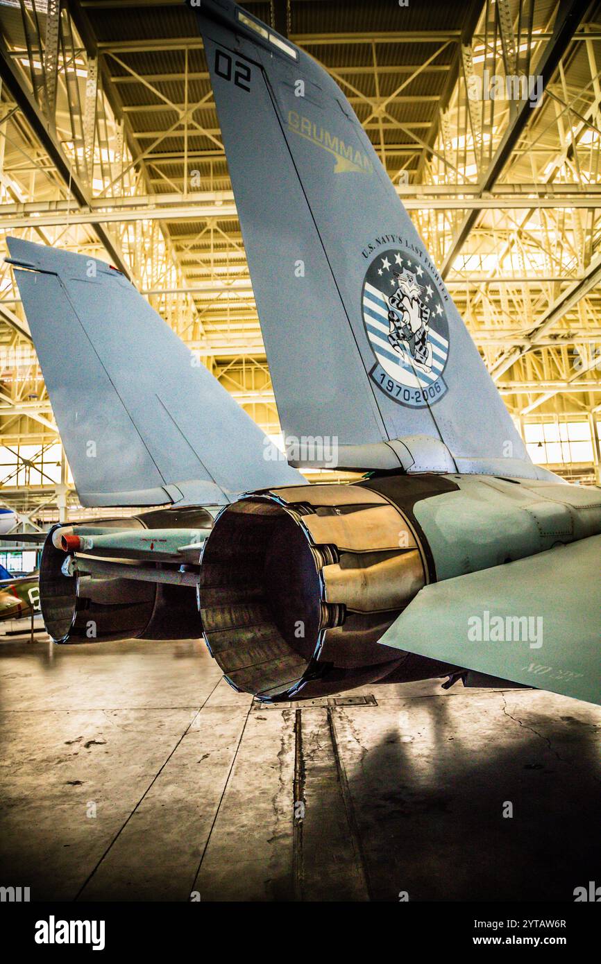 The tail of a fighter jet is on display in a hangar. The jet is painted ...