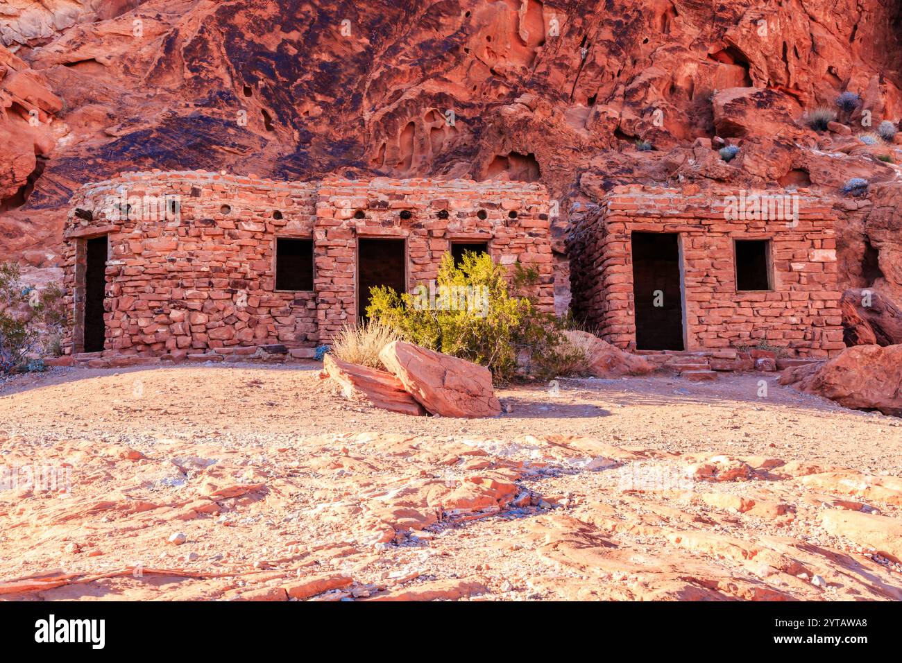 A small group of houses are built out of stone and are surrounded by a ...