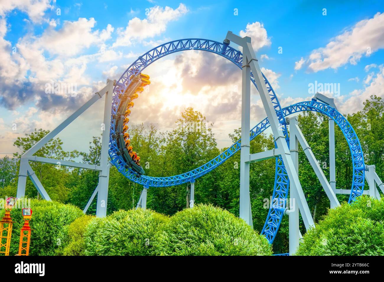 Roller coaster cart with people riding it goes through a loop upside ...