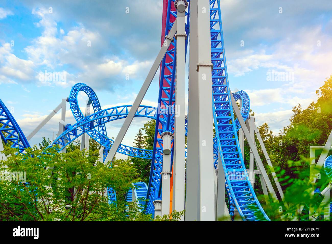View roller coaster loop upside down in green trees bushes city park ...