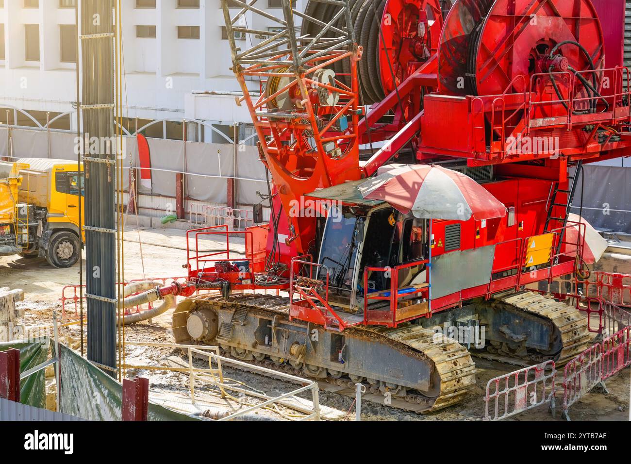 Red Crawler crane stands on dirty ground during the construction of a ...