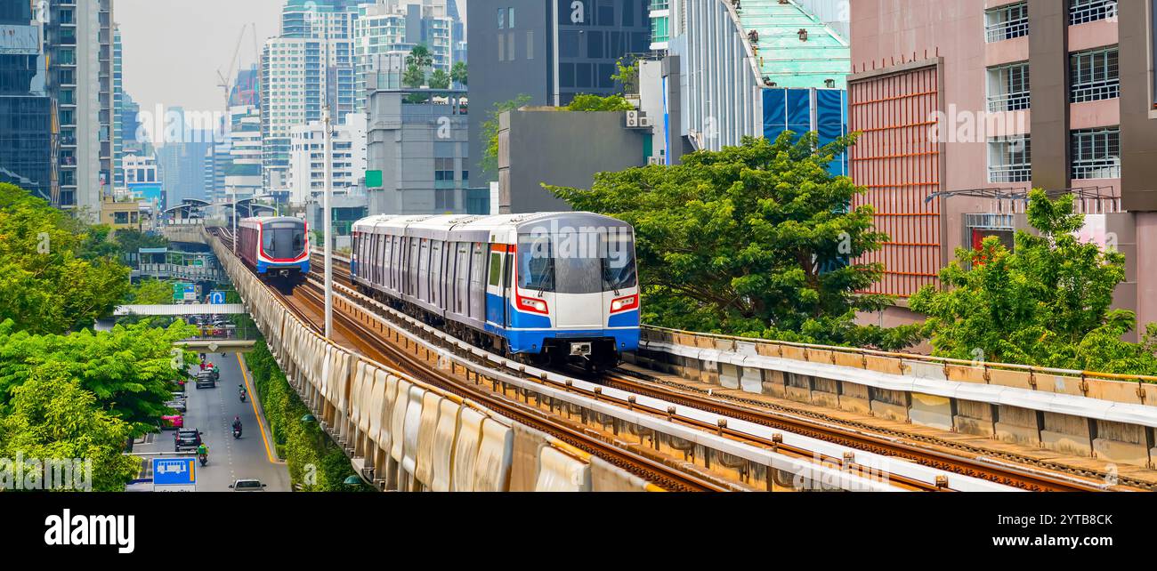 Modern subway electric train over ground on a bridge on stilts among ...