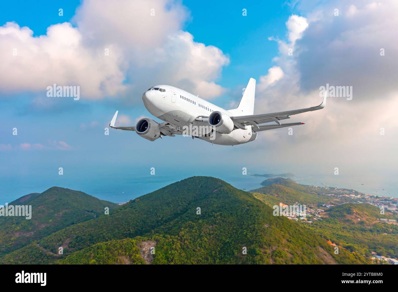 Passenger jet plane flying over beautiful island blue ocean in purity ...