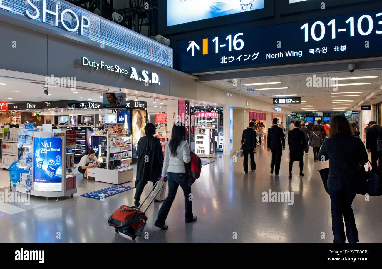 Travelers passing by a duty-free shop inside the terminal building at ...