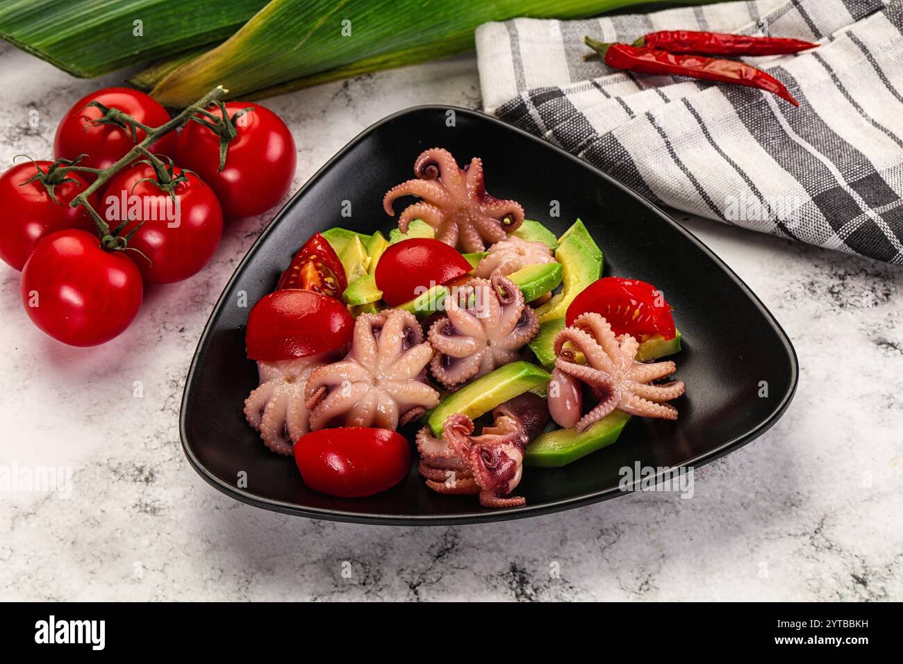 Salad with baby octopus, tomato and avocado Stock Photo - Alamy