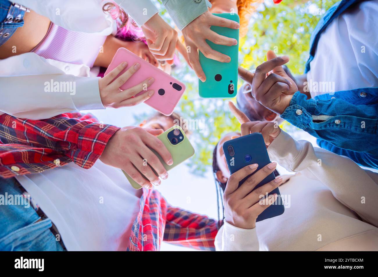 Group of friends holding different smartphones together, showing ...
