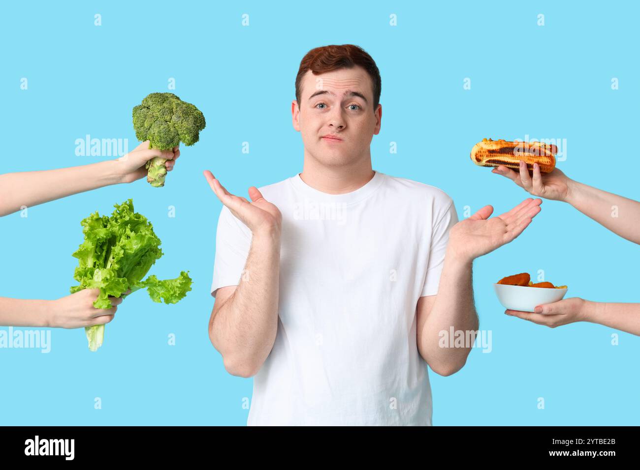 Young thoughtful overweight man choosing between healthy and unhealthy ...