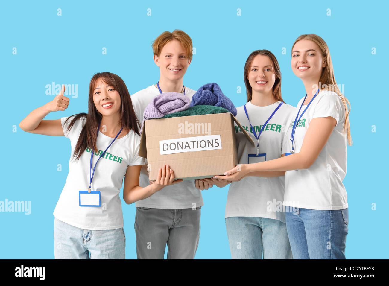 Group of volunteers with donations on blue background Stock Photo - Alamy