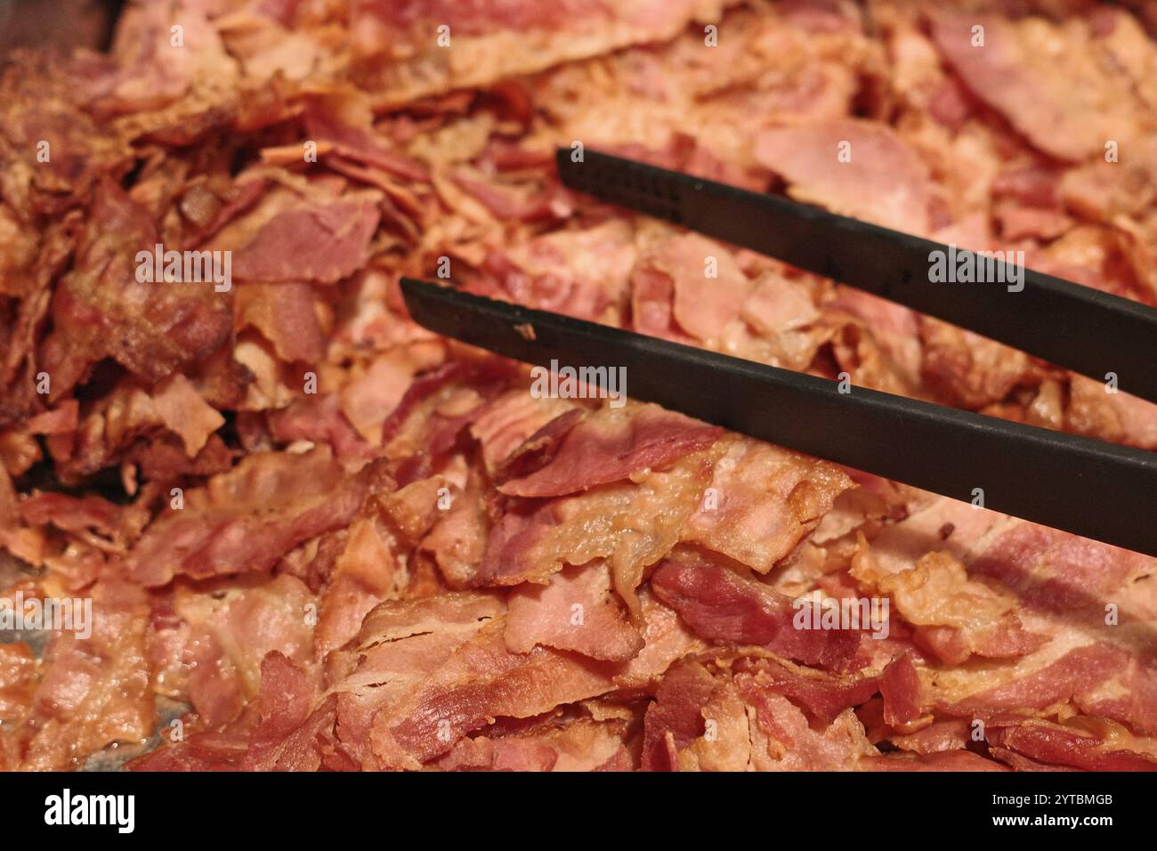 A container of fried bacon from the breakfast of a buffet restaurant ...