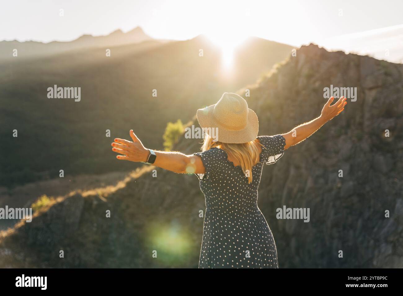 The woman joyfully embraces the beauty of nature as the sun rises over ...