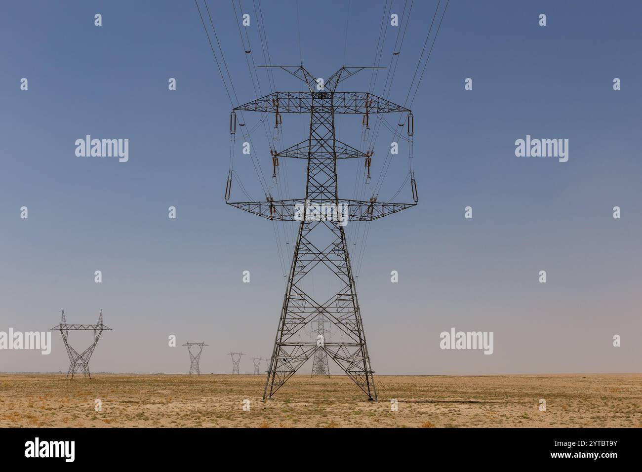 Tall transmission towers stretch across the barren landscape of ...