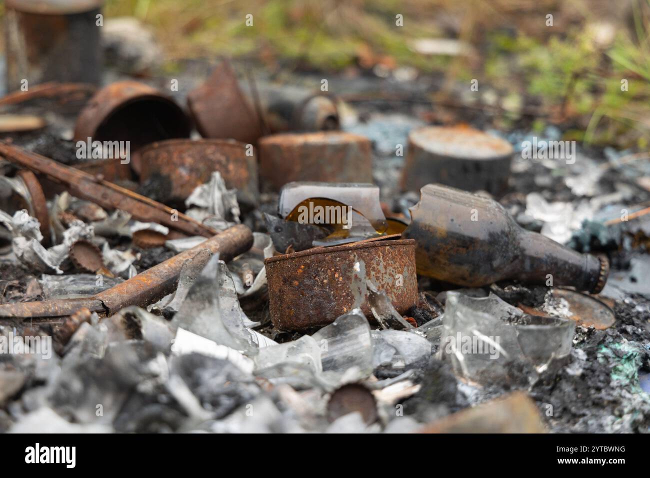 Old, rusted metal cans in burned ash. Trash in abandoned army base ...