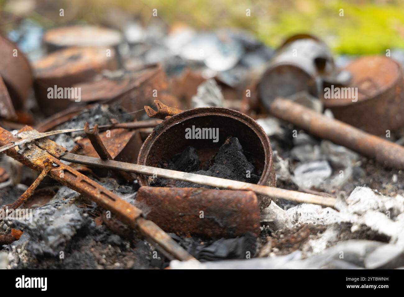 Old, rusted metal cans in burned ash. Trash in abandoned army base ...