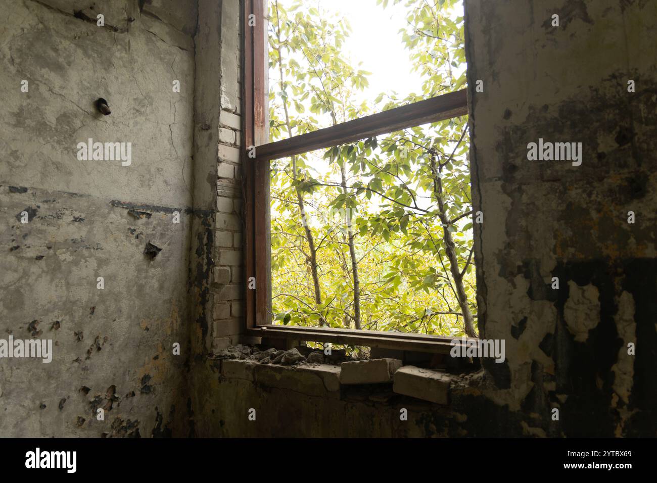A broken, empty window of building ruins from Soviet times. Collapsed brick wall with window ...