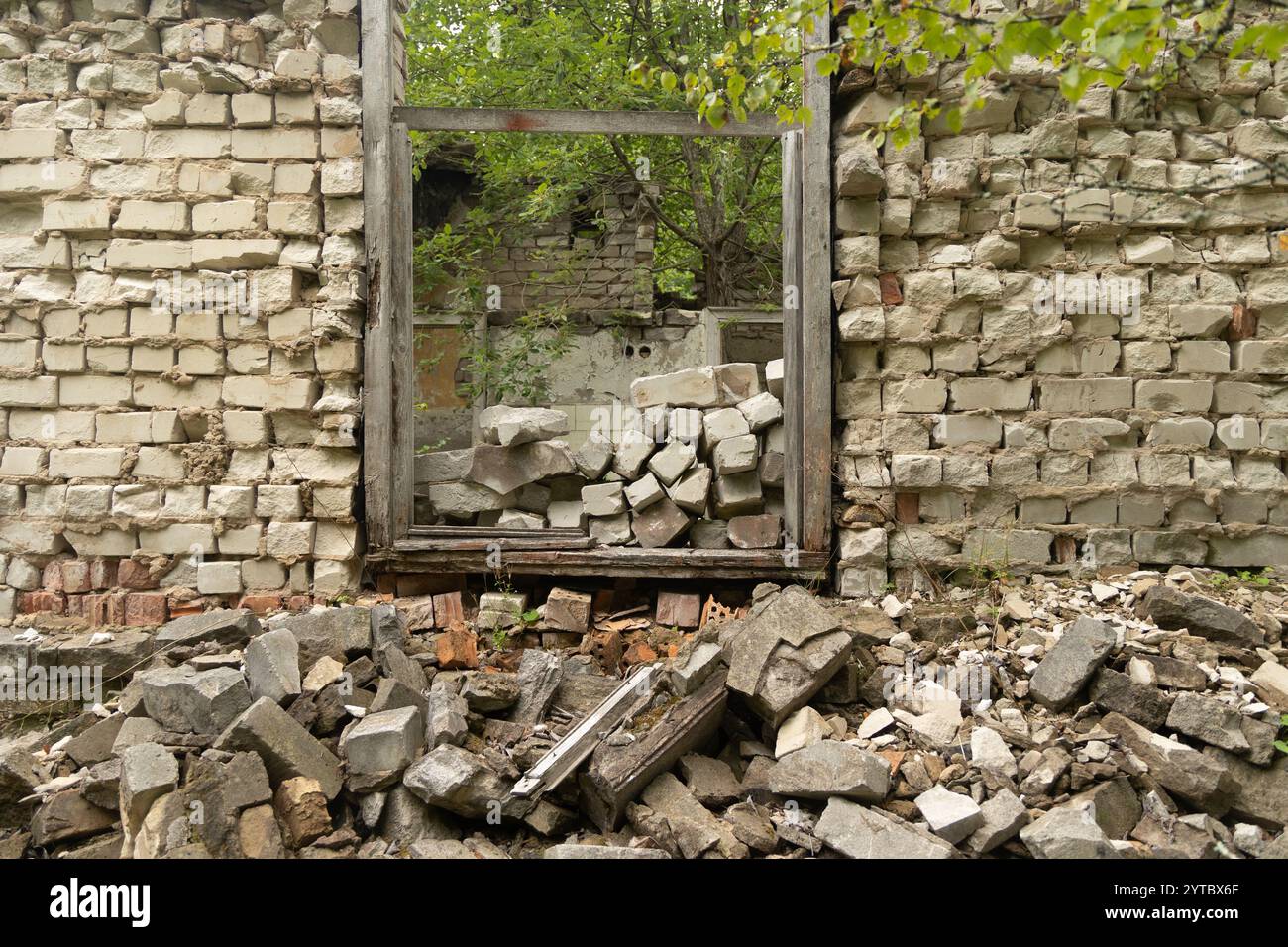 A broken, empty window of building ruins from Soviet times. Collapsed brick wall with window ...
