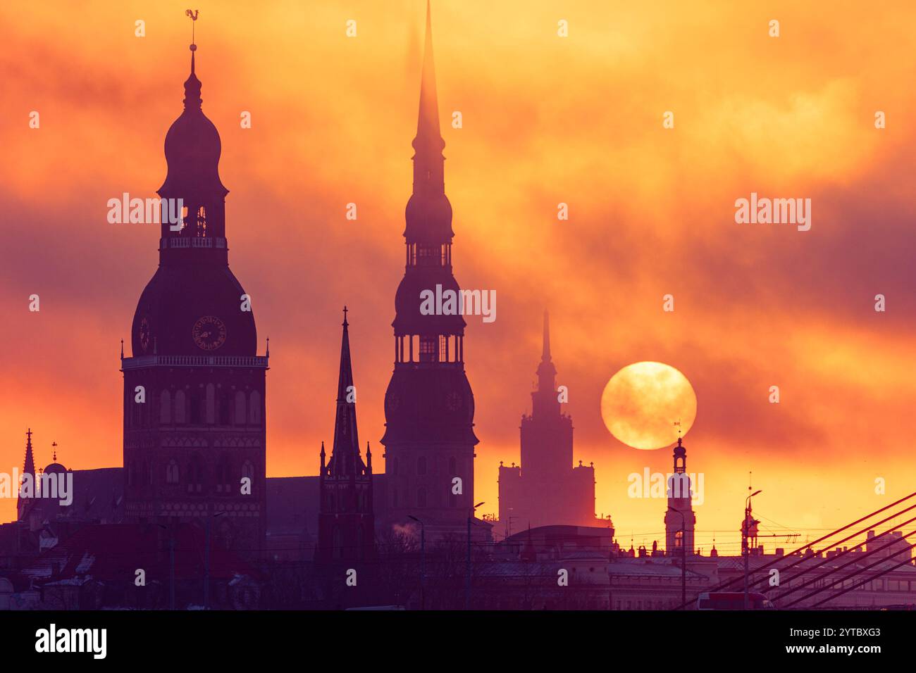 A beautiful cityscape of Riga, Latvia during sunrise. Church towers against colorful sky. City ...