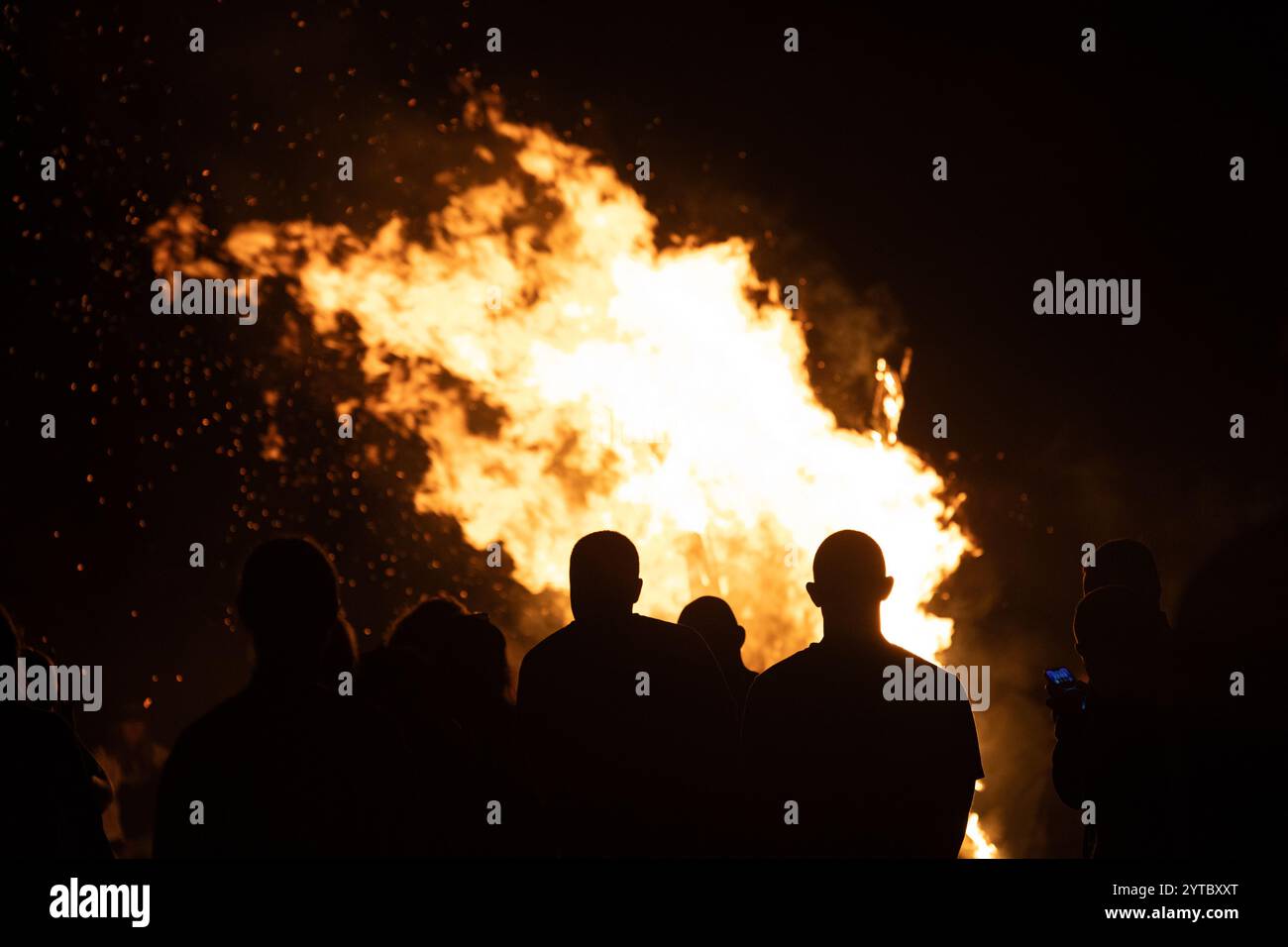 People watching the fire burn on the beach of Baltic sea during Fire ...