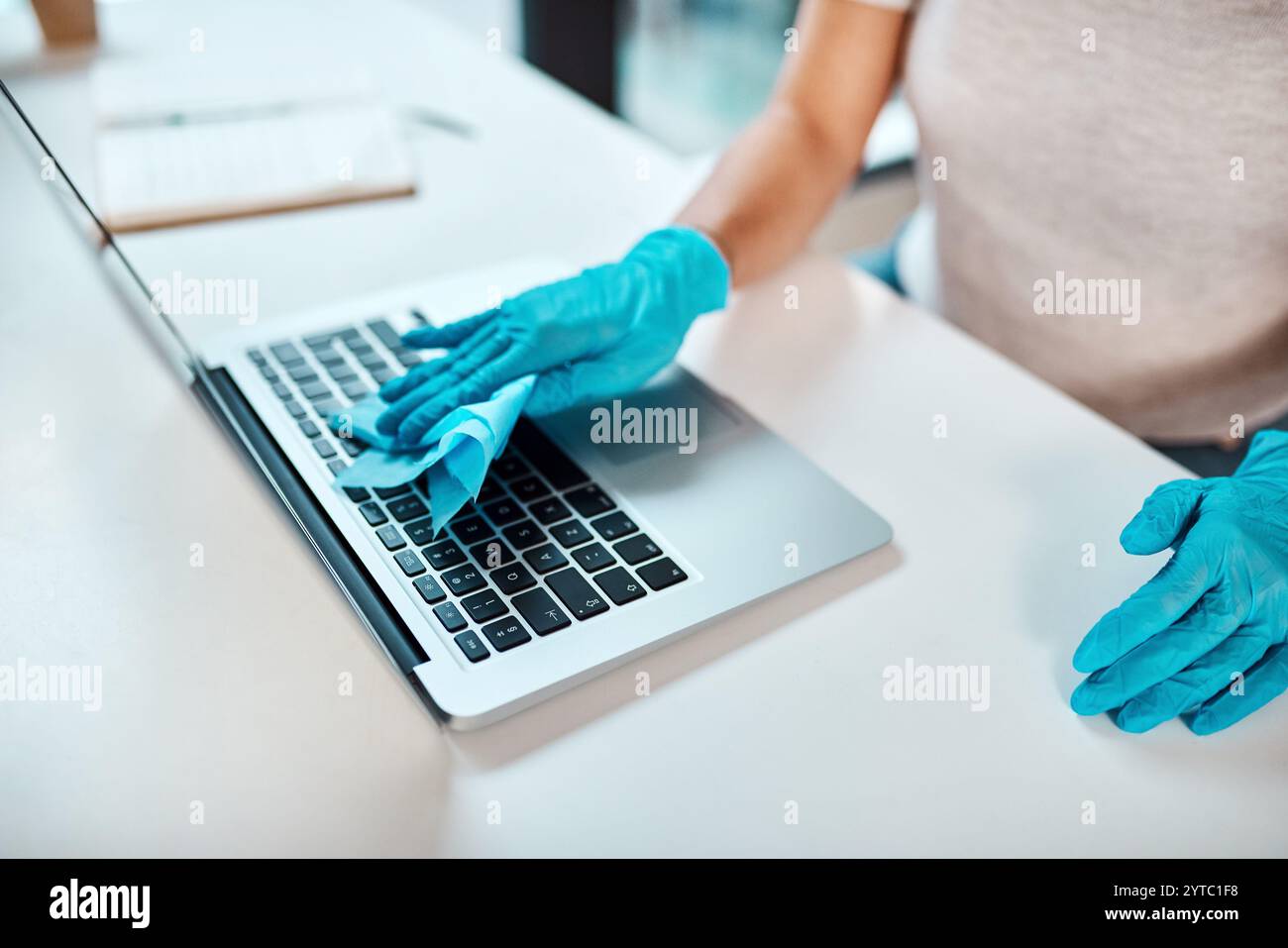 Woman, laptop and cleaning keyboard with cloth in office, professional ...