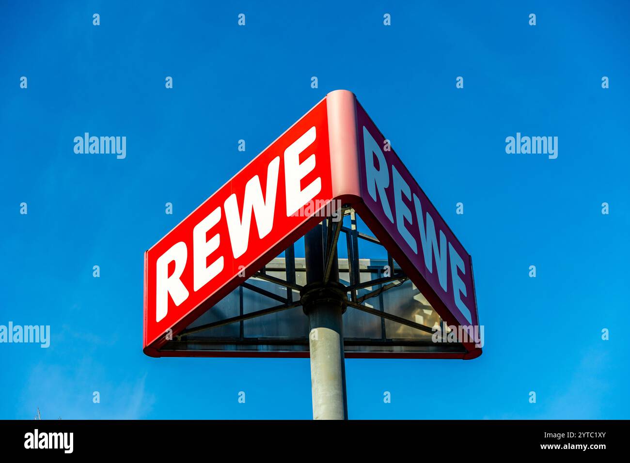 Logo of the German supermarket chain Rewe in front of a blue sky in Bad ...