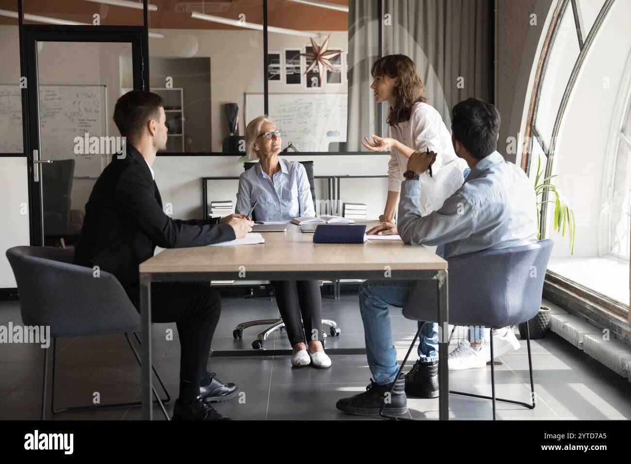 Four diverse colleagues solve work-related issues in conference room ...