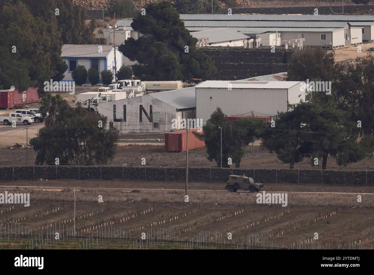 An Israeli military vehicle rides along a road next to the UN base on ...