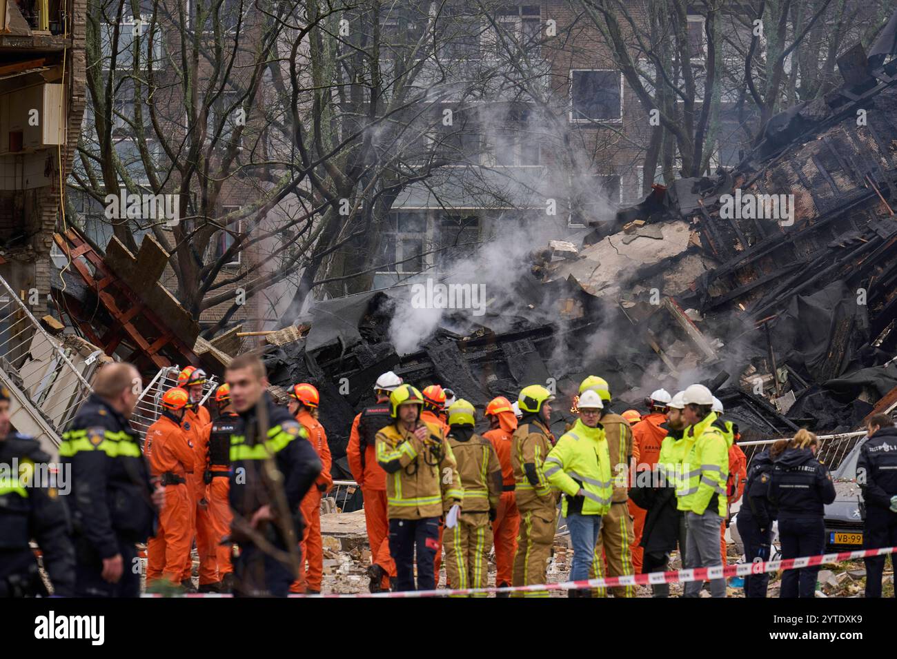 Firefighters stand by a building destruction at the site of an ...