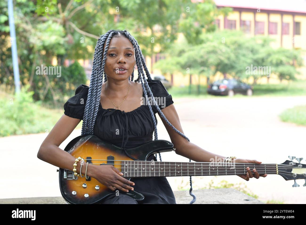 Image of young black african woman playing acoustic guitar outdoor ...