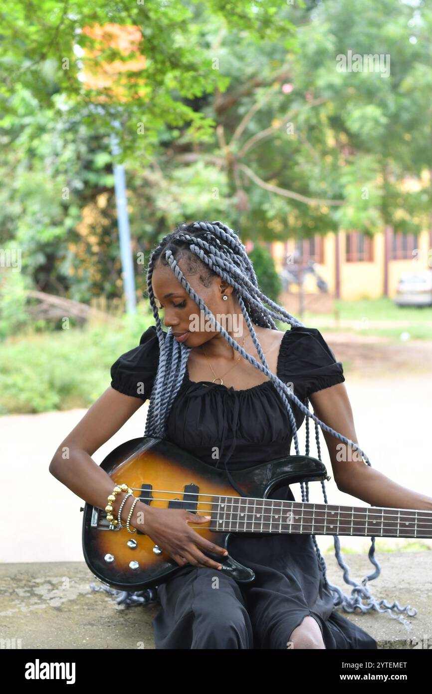 Image of young black african woman playing acoustic guitar outdoor ...