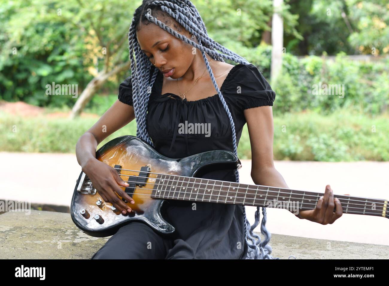 Image of young black african woman playing acoustic guitar outdoor ...