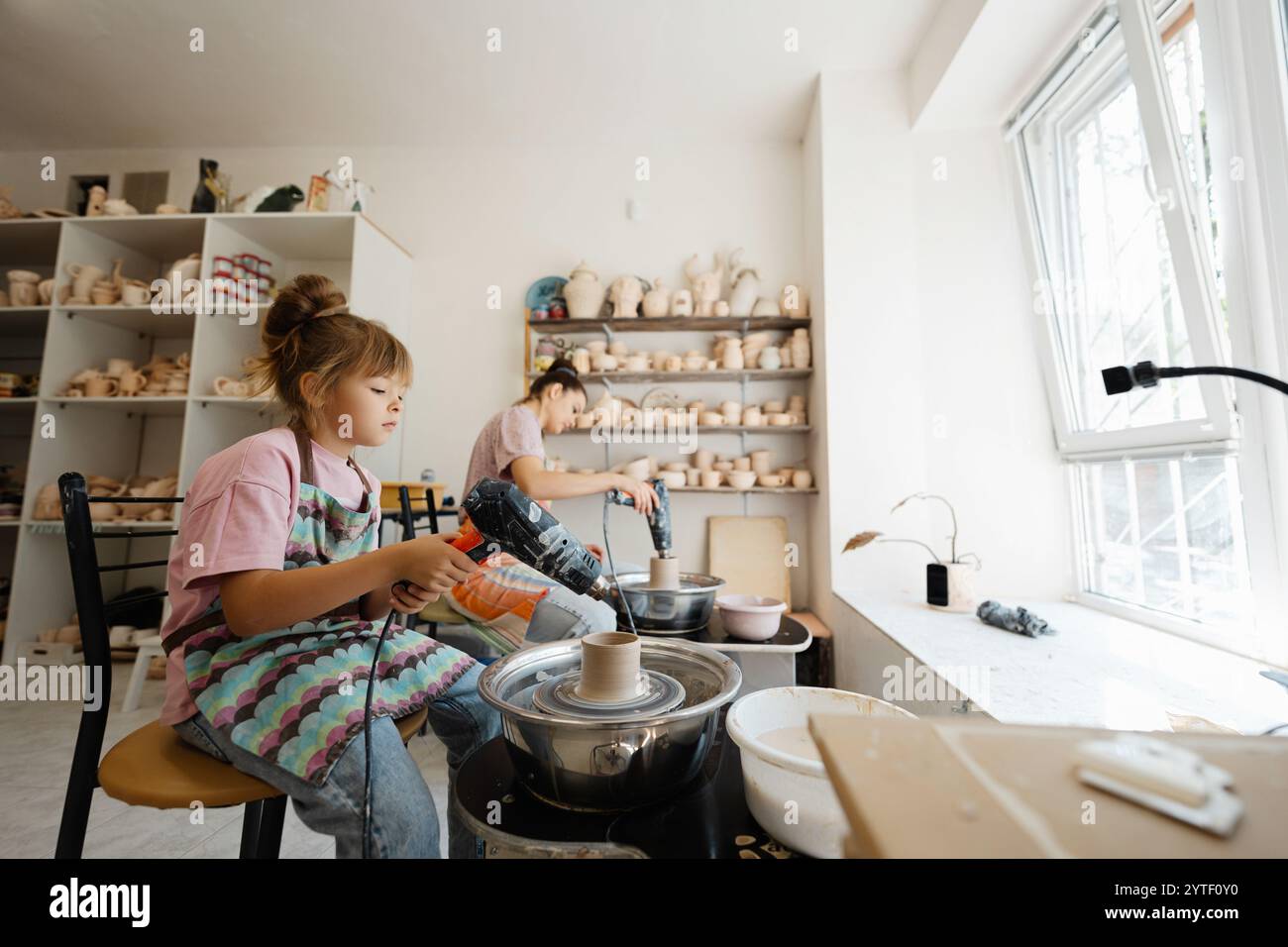 Children learn pottery skills in a bright, sunny studio space Stock ...
