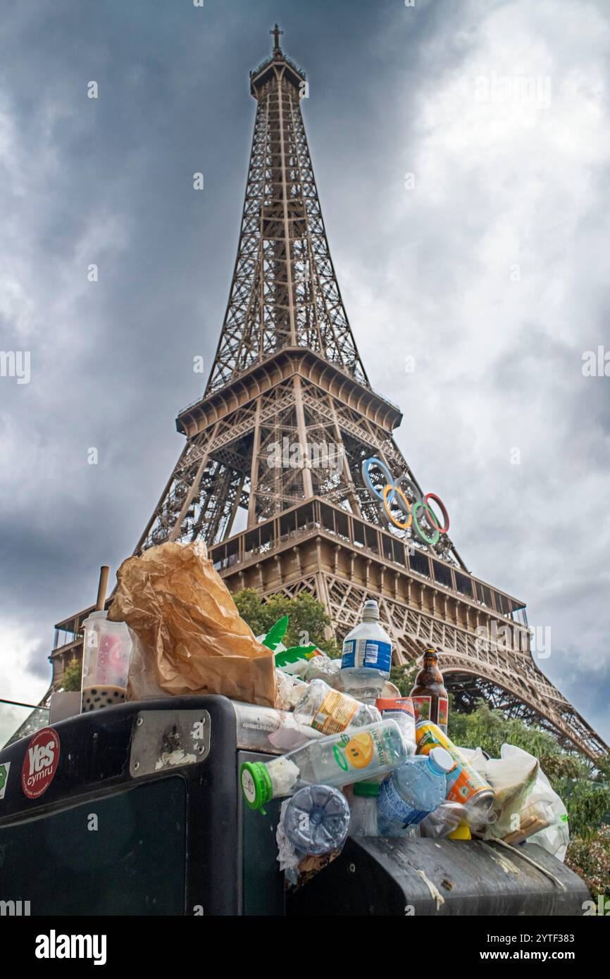 An overflowing rubbish bin on a pavement in front of the Eiffel Tower ...