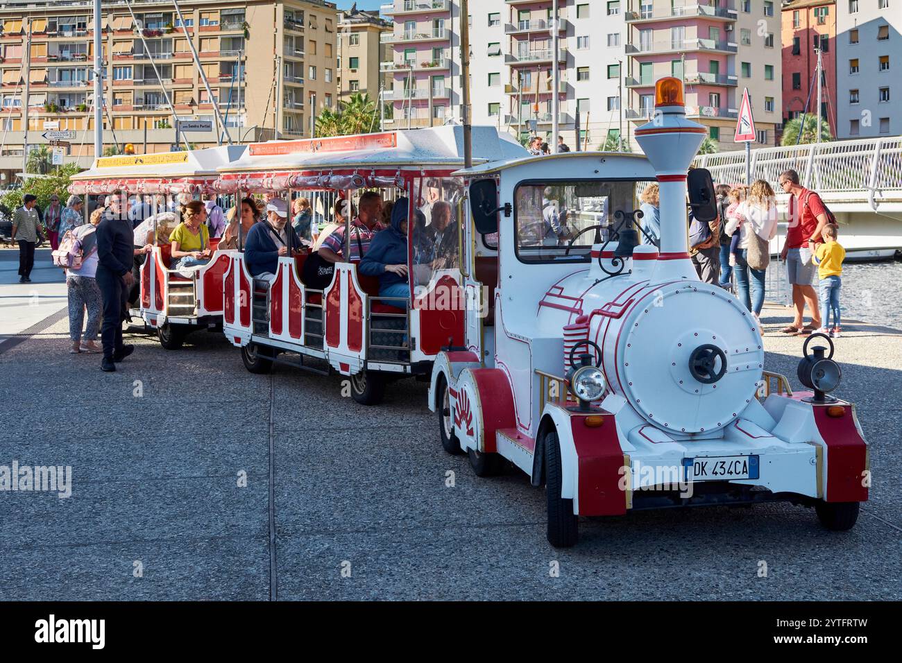 Savona. Italia - December 07, 2024: People are seated on a vibrant city ...
