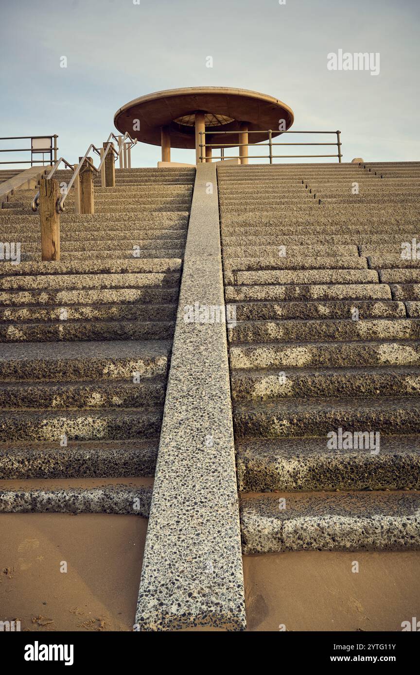 Steps on seawall leading up to seafront shelter Stock Photo - Alamy