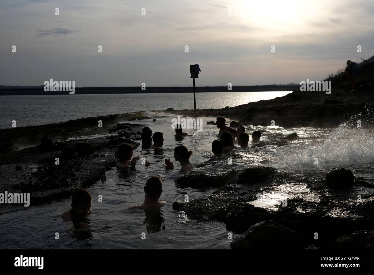 People enjoy a hot water pool fed by a hydrothermal spring near Mount ...