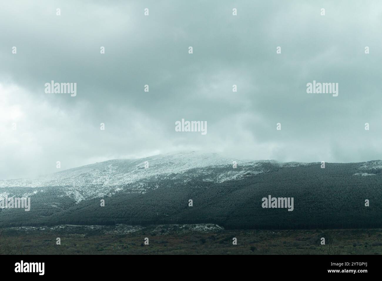 A scenic mountain in Spain, crowned with a dusting of snow. Cloudy sky ...